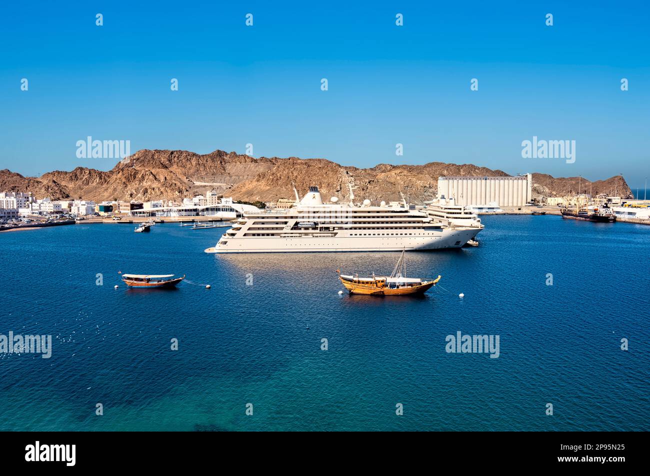 Cruise ship and traditional dhows in the Mutrah Harbor, Muscat, Oman ...