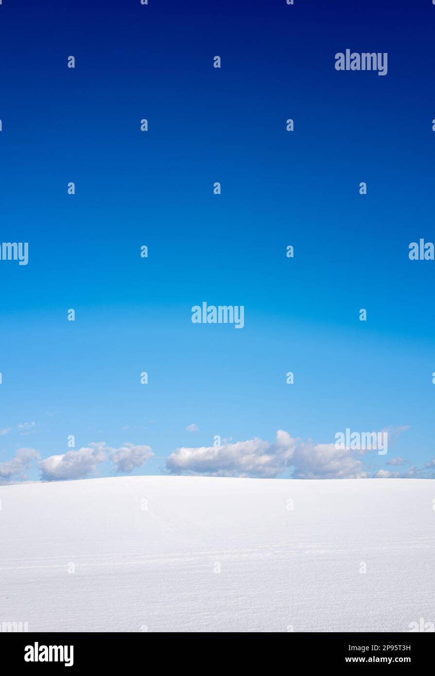 Snow covered field with few clouds and clear blue sky Stock Photo - Alamy