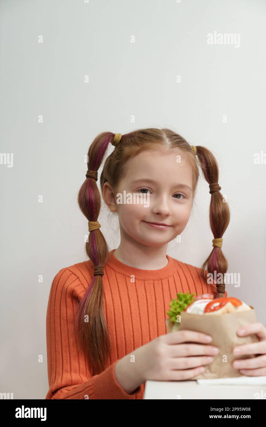 Pretty little girl eats souvlaki and pita bread in traditional Greek ...