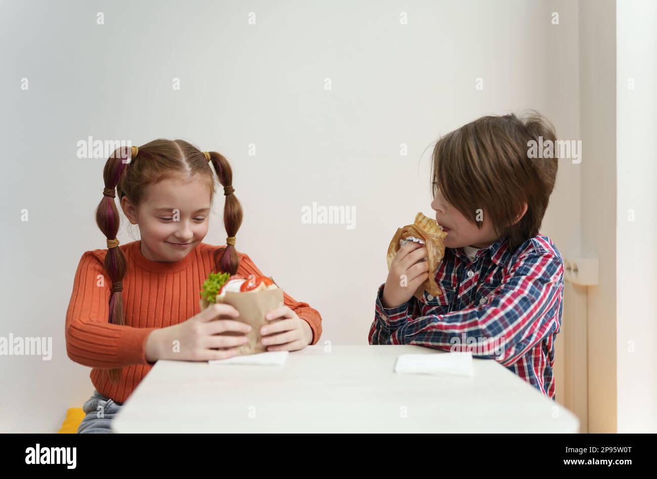Two little kids eating gyros and souvlaki in Greek restaurant ...