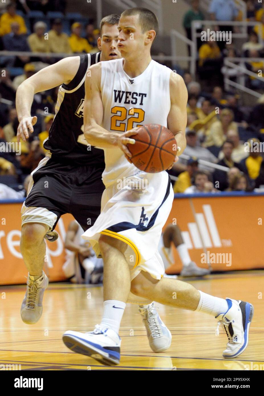 West Virginia guard Alex Ruoff (22) drives the lane as Providence guard ...