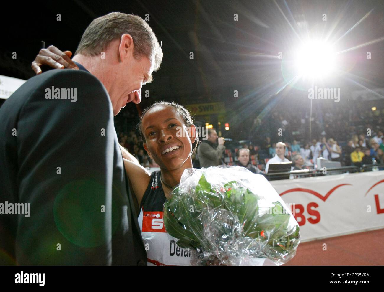 Meseret Defar from Ethiopia, right, hugs meeting director Alain Blondel ...