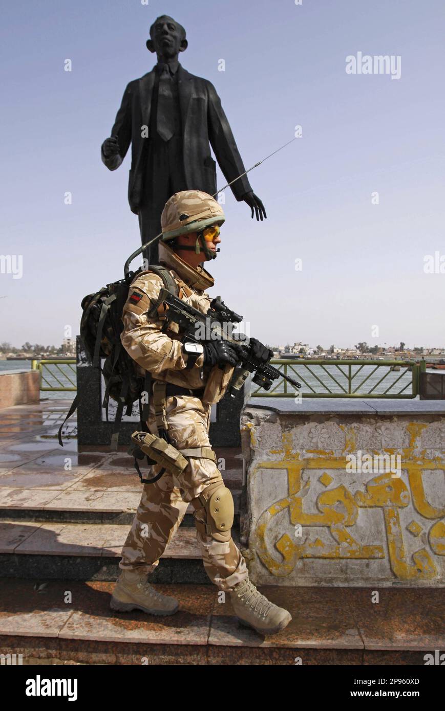 A British soldier stands guard in front of a statue of Badr Shakir al ...