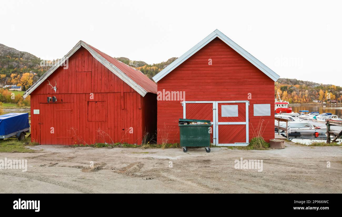 Red wooden barns stand at the sea coast. Norway, Snillfjord, Sor ...