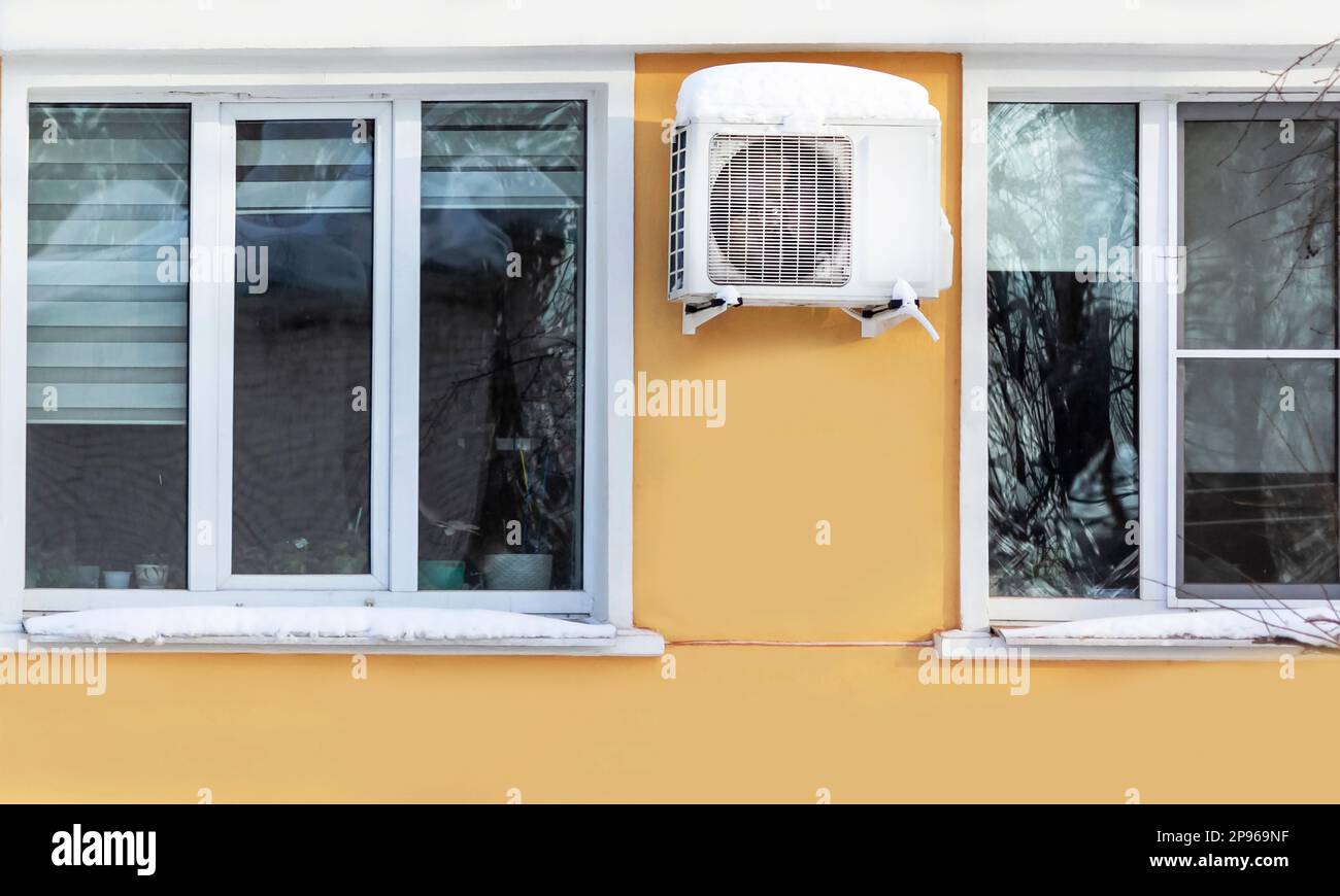 An air conditioner is installed on the wall of the residential building ...