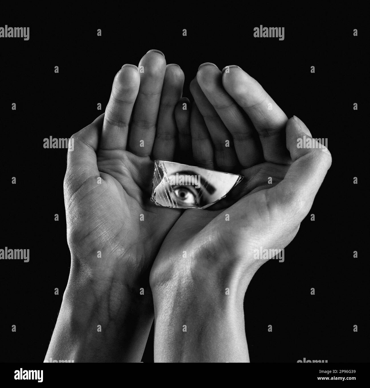 A close-up shot of two hands clasping a container with a small object ...