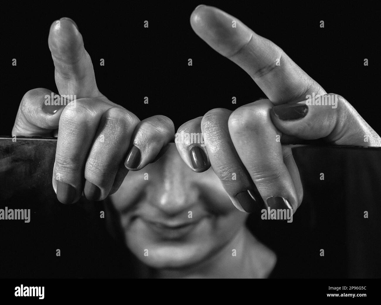 The hands holding a mirror reflecting the a smiling woman with two ...
