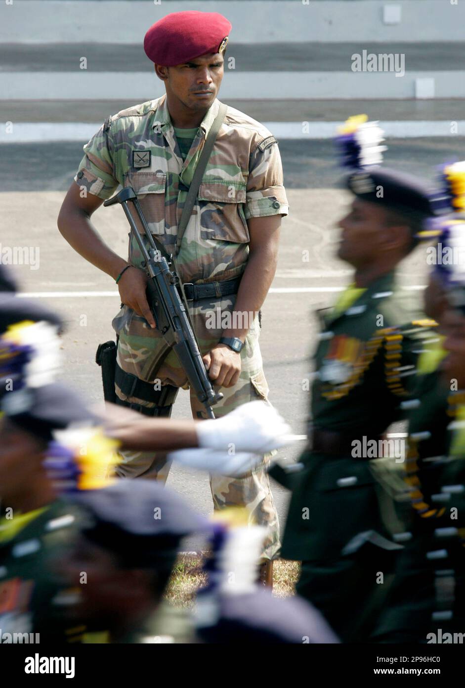 A Sri Lankan army commando stands guard as soldiers march past during ...