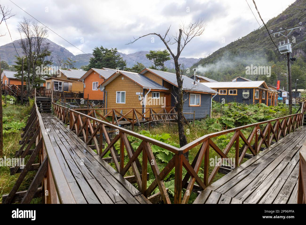 Small colorful houses and nalca plants along the wooden paths of Tortel ...