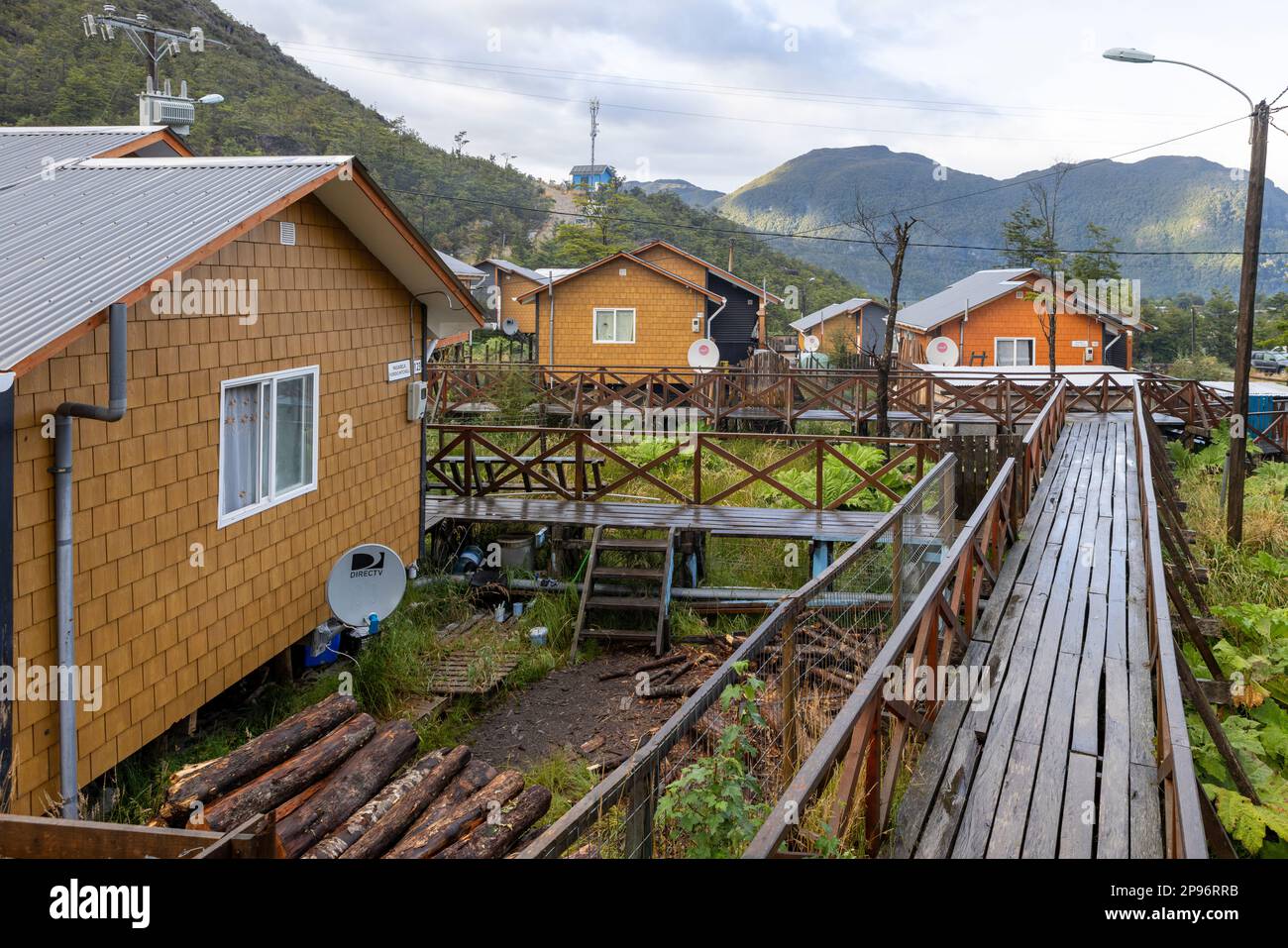 Small colorful houses and nalca plants along the wooden paths of Tortel ...