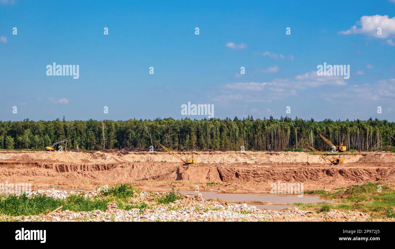 Industrial quarry. Sand mining. Excavators against the backdrop of ...