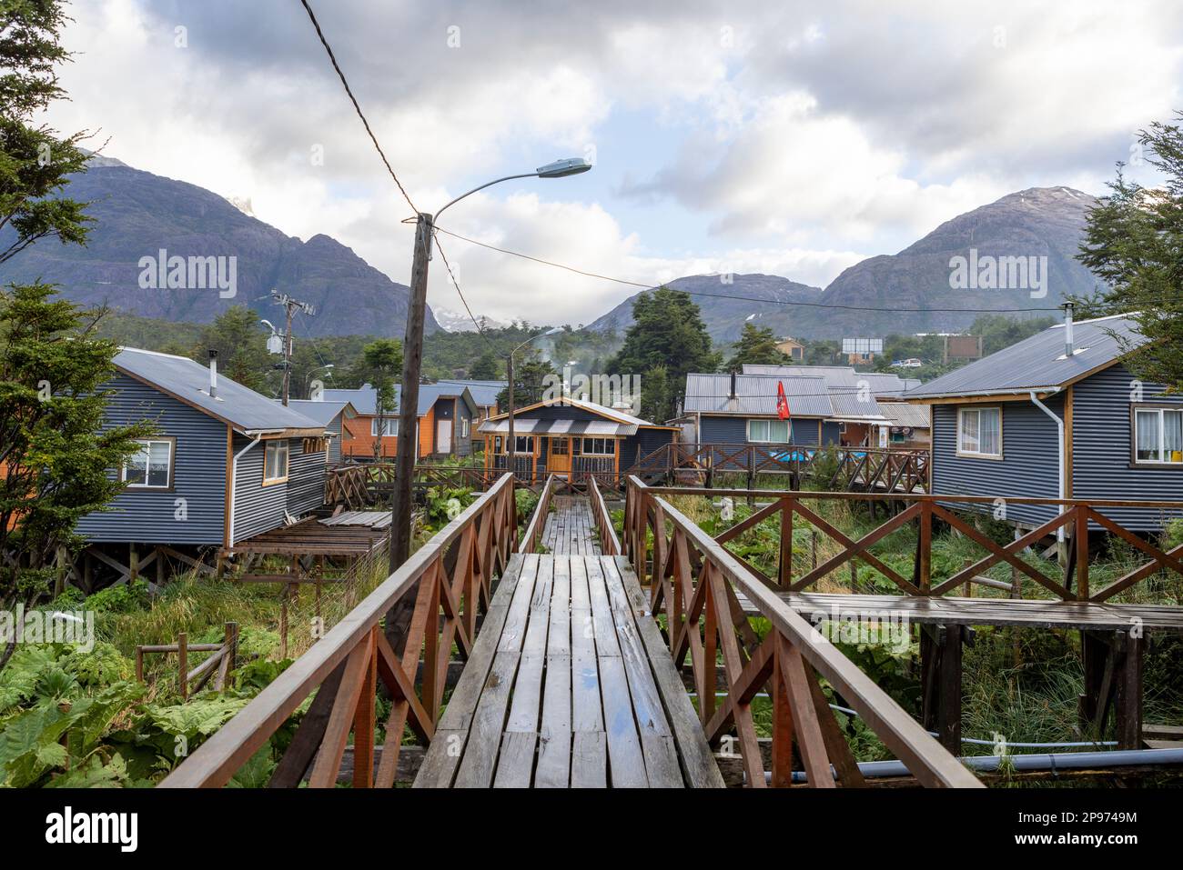 Small colorful houses and nalca plants along the wooden paths of Tortel ...