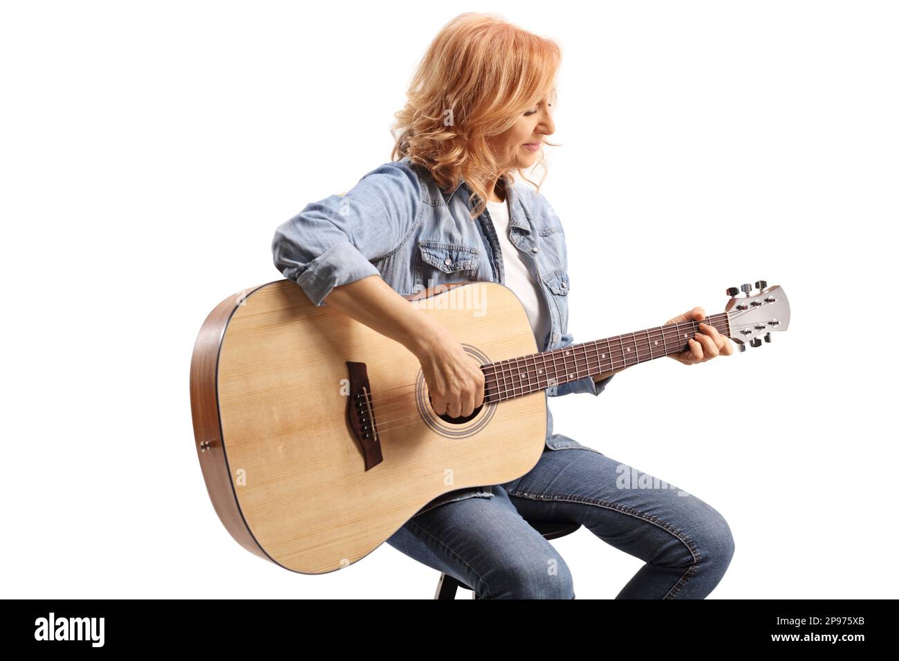 Woman musician sitting on a chair and playing an acoustic guitar ...