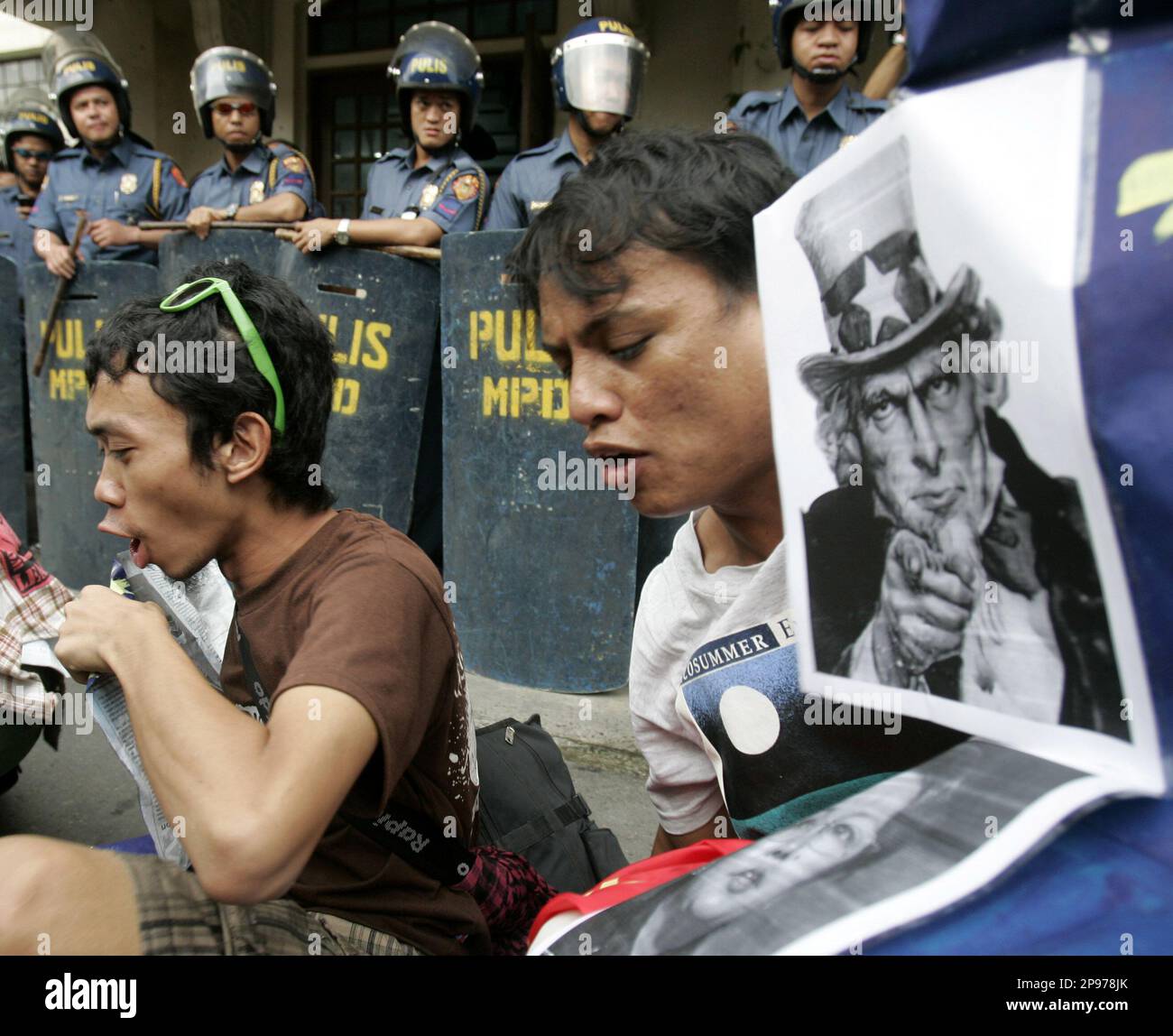 Protesters display posters of Uncle Sam and Philippine President Gloria ...