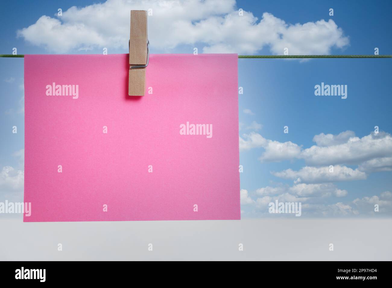 a sticky note hung with a clothespin on a clothesline with copy space ...