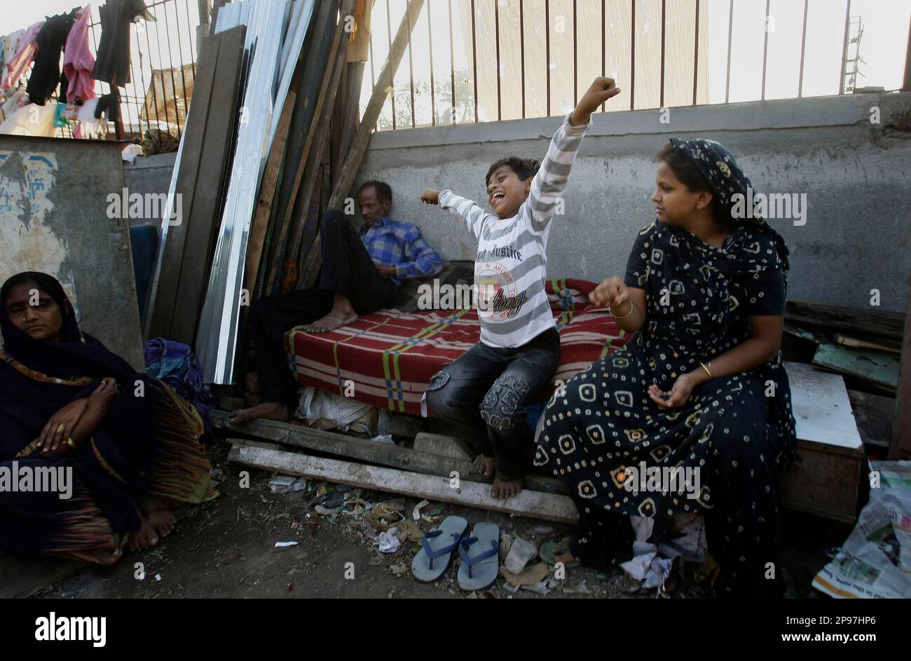 Azharuddin Mohammed Ismail, 10, center, stretches as his mother Shamim ...