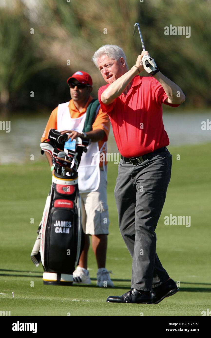 Former U.S. President Bill Clinton hits an iron shot, as he takes part ...