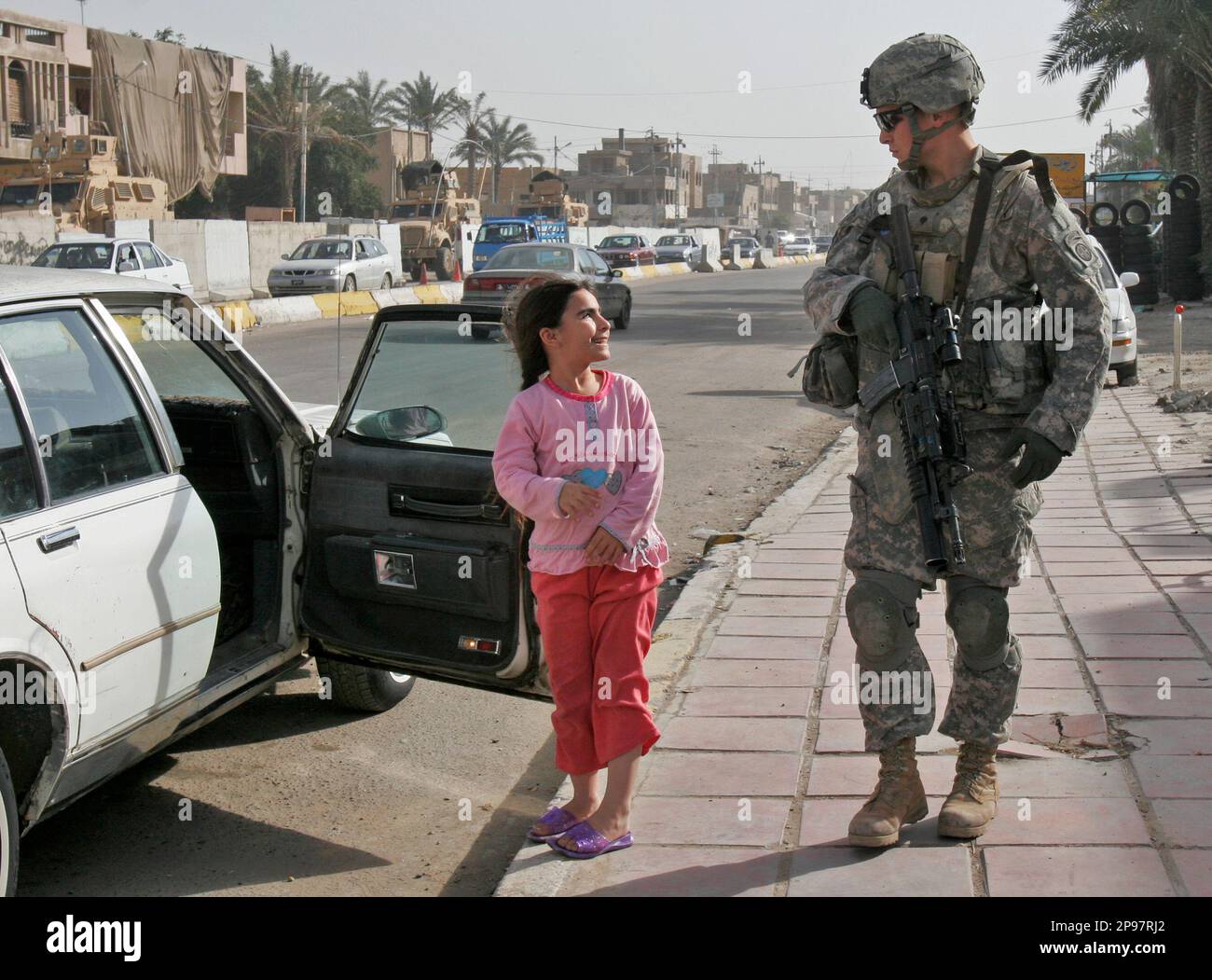 An Iraqi girl smiles at a US soldier at a checkpoint in the Dora ...