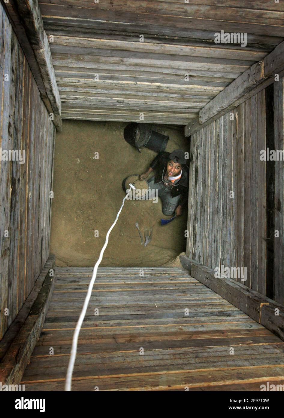 A Palestinian smuggler at the bottom of a shaft leading to a tunnel ...