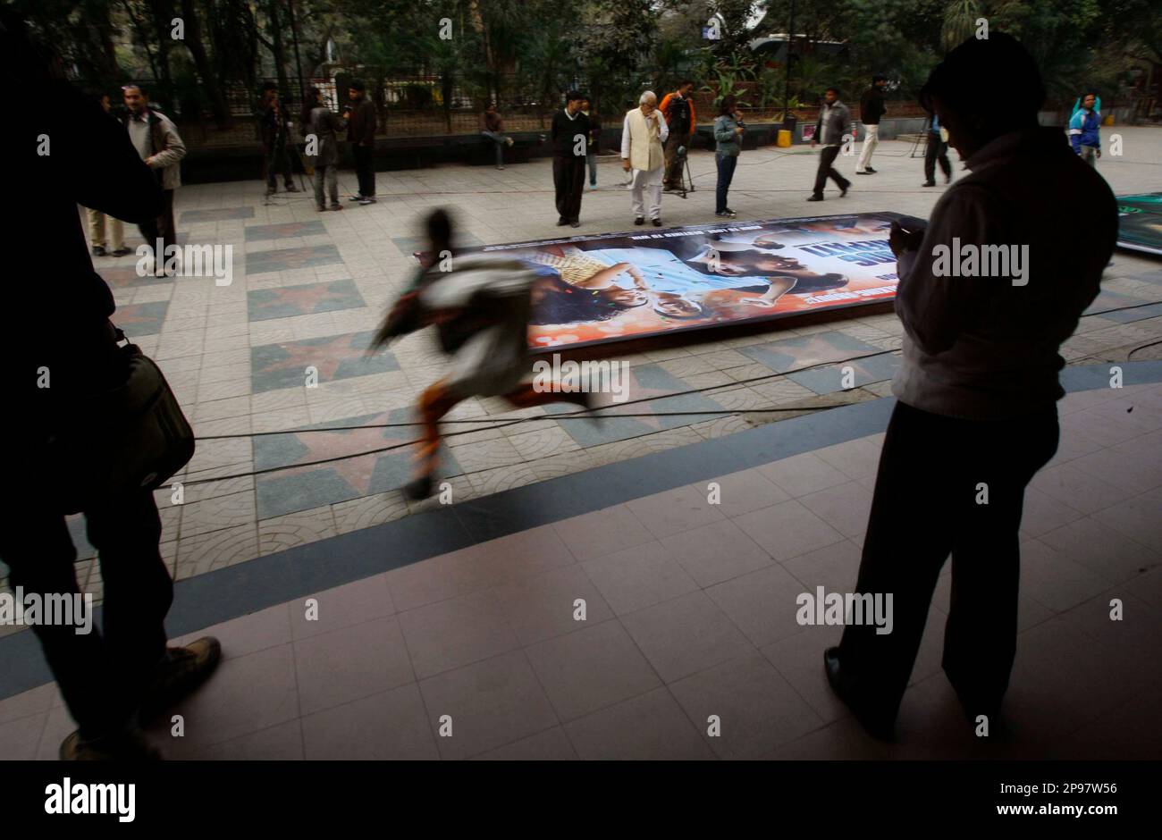 A rag picker boy runs after seeing a policeman, unseen, as a billboard ...