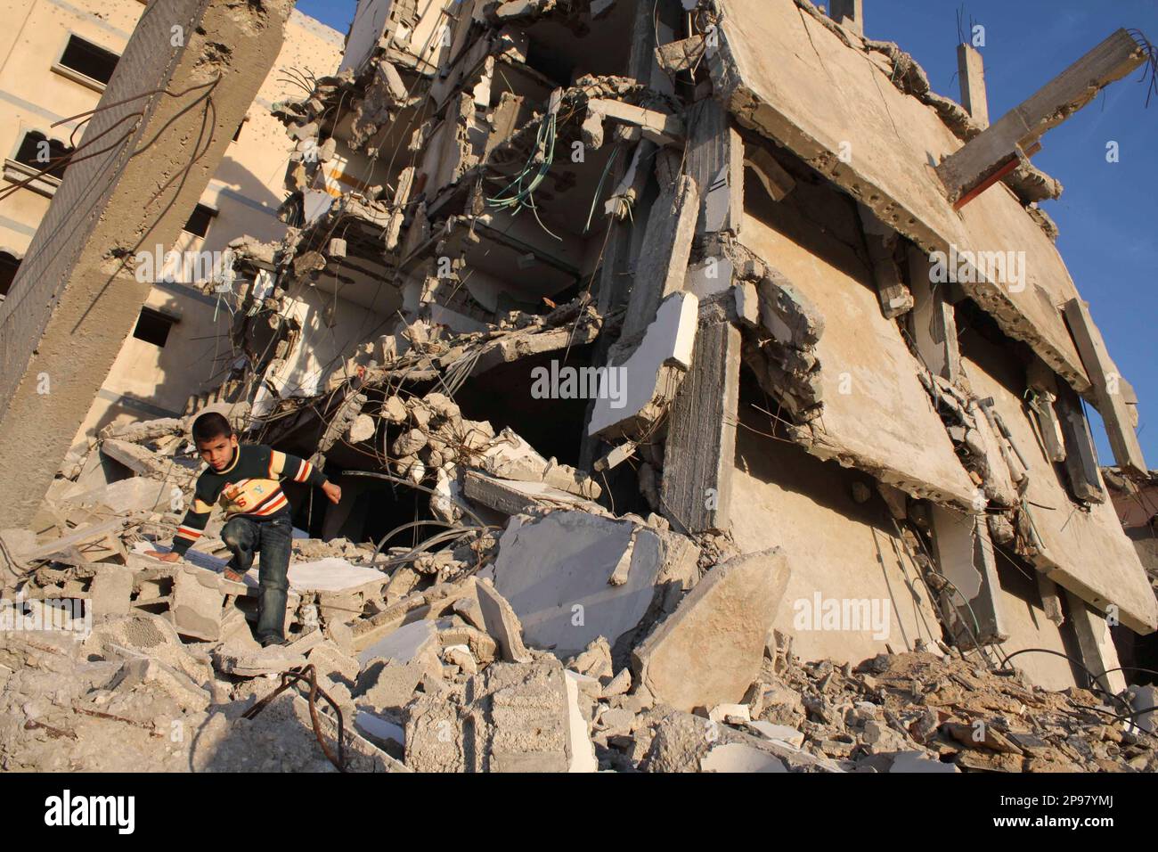 A Palestinian boy walks on the rubble of a building in Rafah in the ...