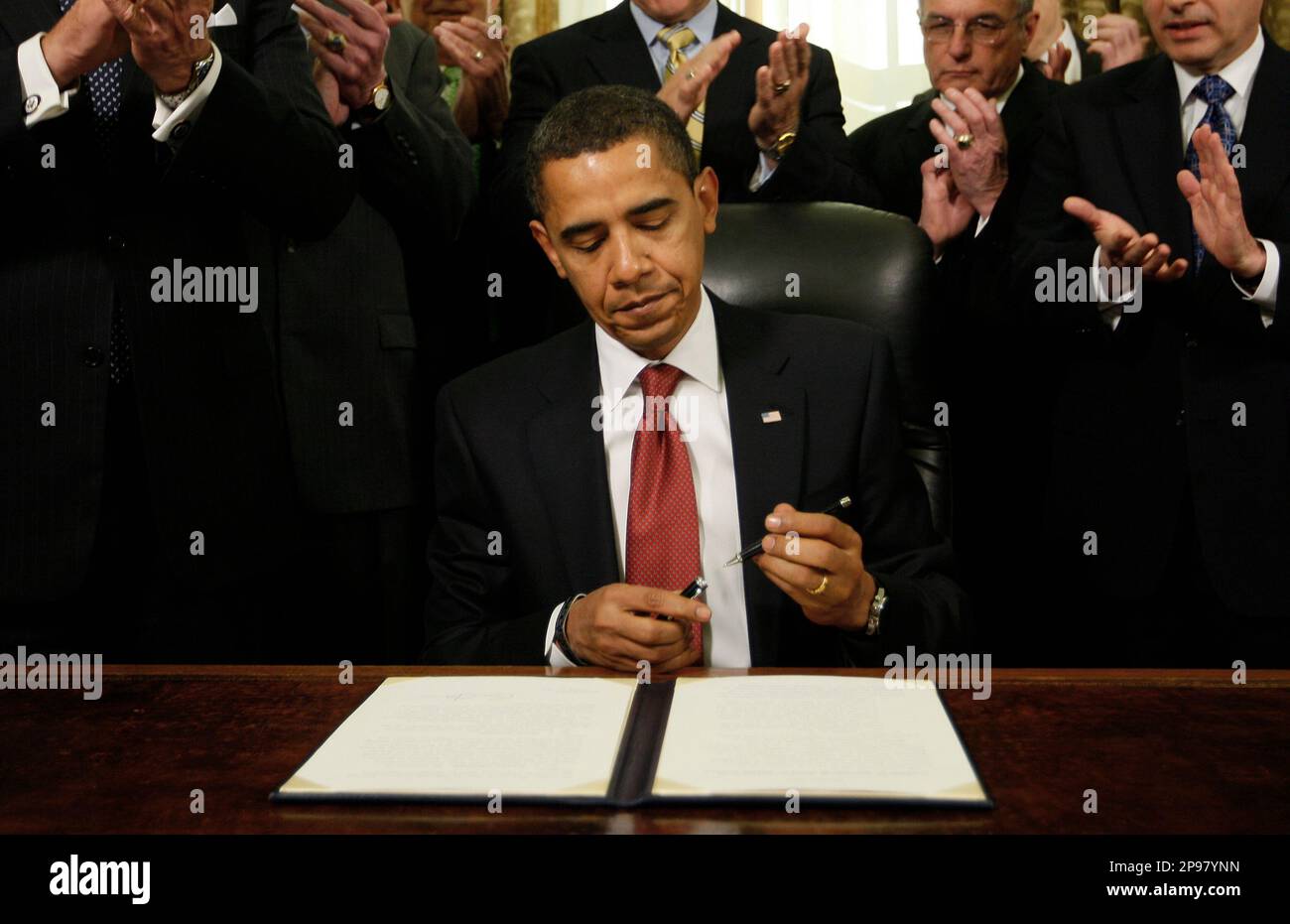 President Barack Obama is applauded as he caps his pen after he signed ...