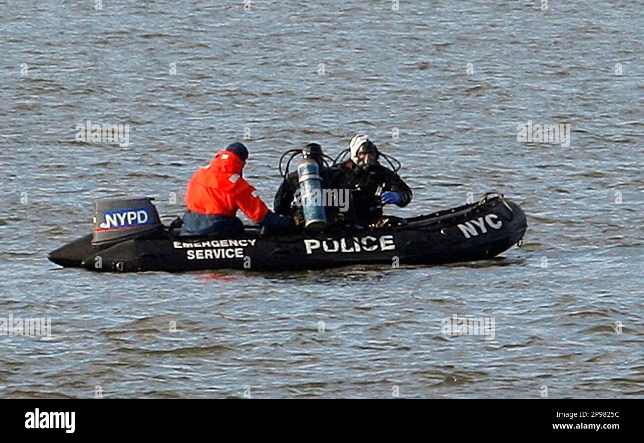 New York City police divers ride in a inflatable boat after divers ...