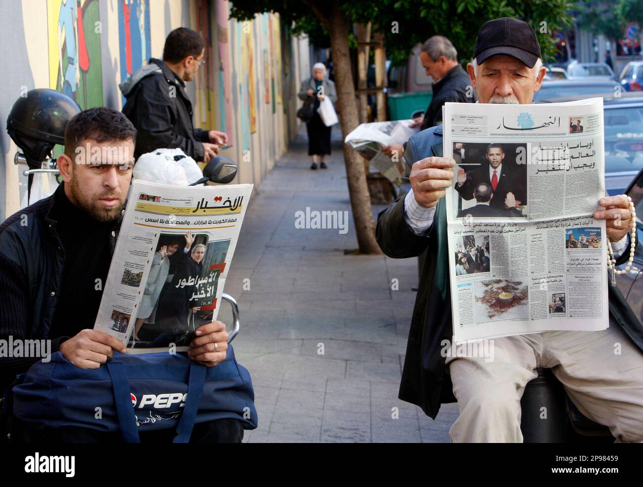 Lebanese men, read newspapers with front pages pictures showing the ...