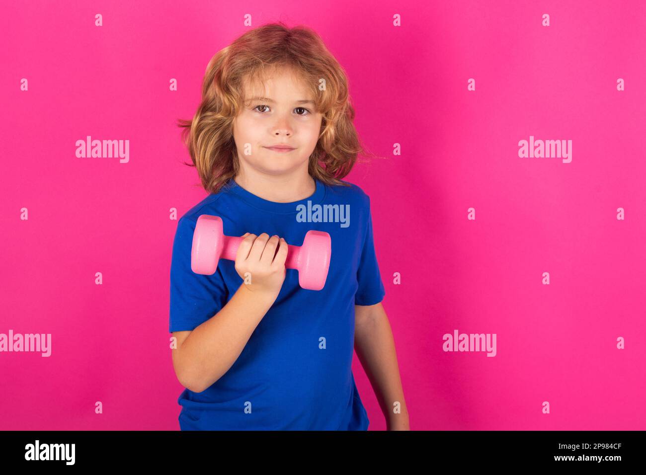 Sporty kids, studio isolated portrait. Child boy raising a dumbbell ...