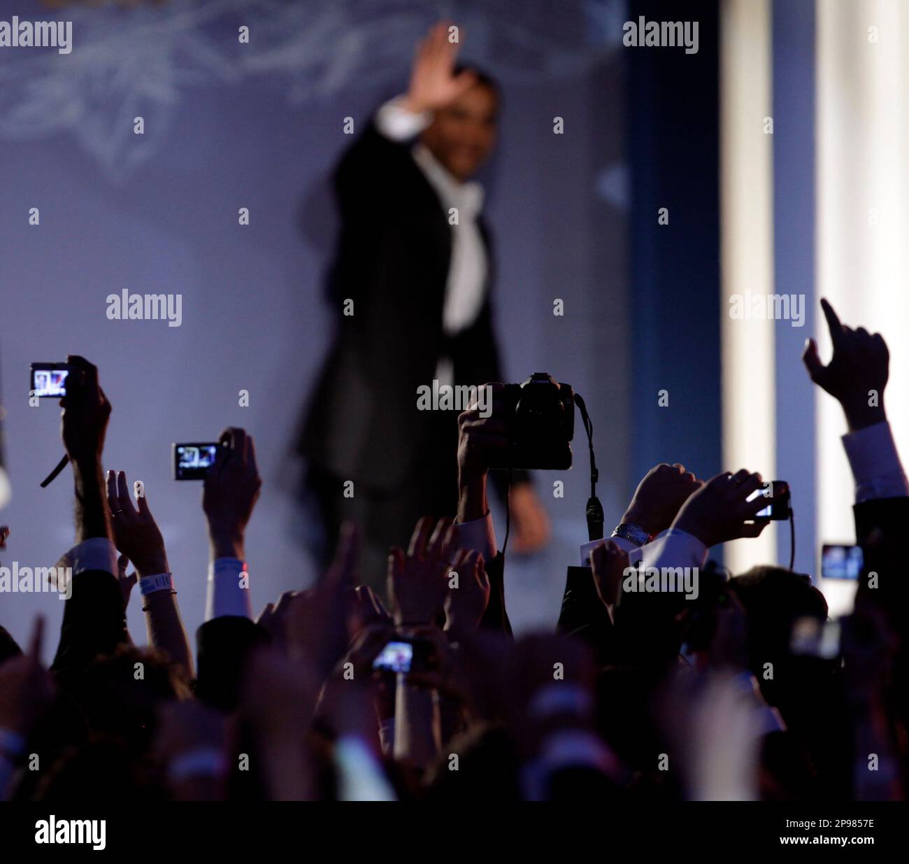 People hold up their camers and cell phones as President Barack Obama ...