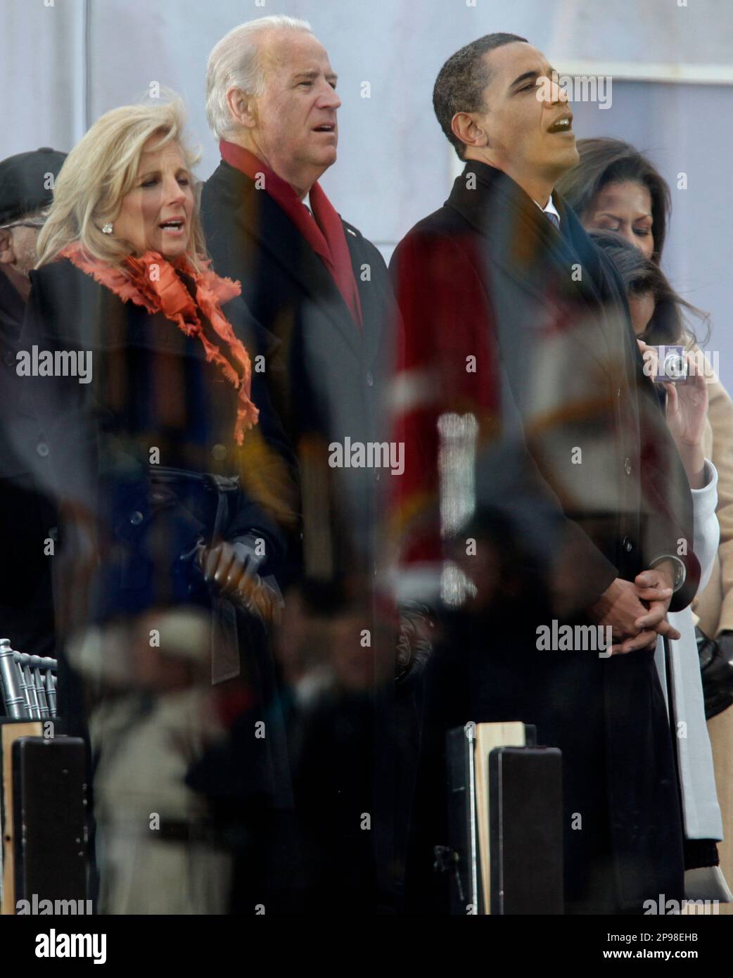 standing behind bulletproof glass, President-elect Barack Obama and his ...