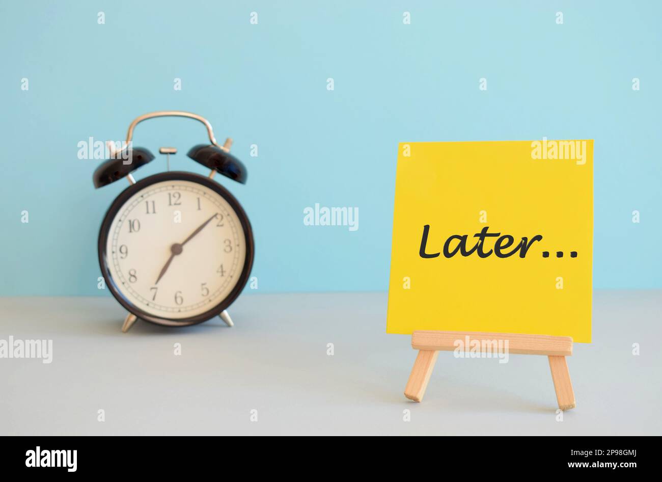 Procrastination, delay and urgency concept. White alarm clock with a ...