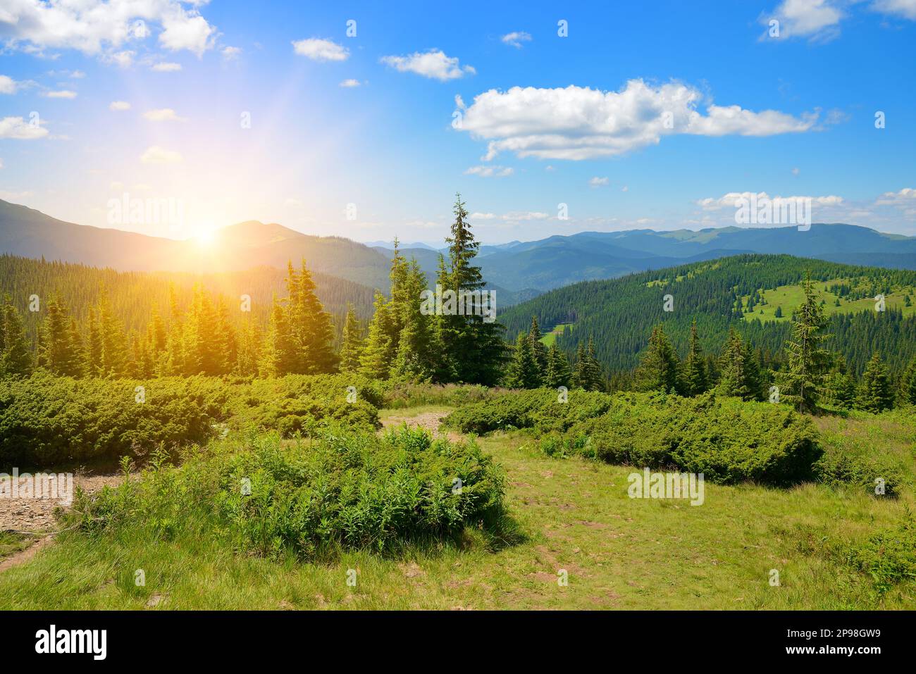 Beautiful bright sunrise in mountains and blue sky with white clouds ...