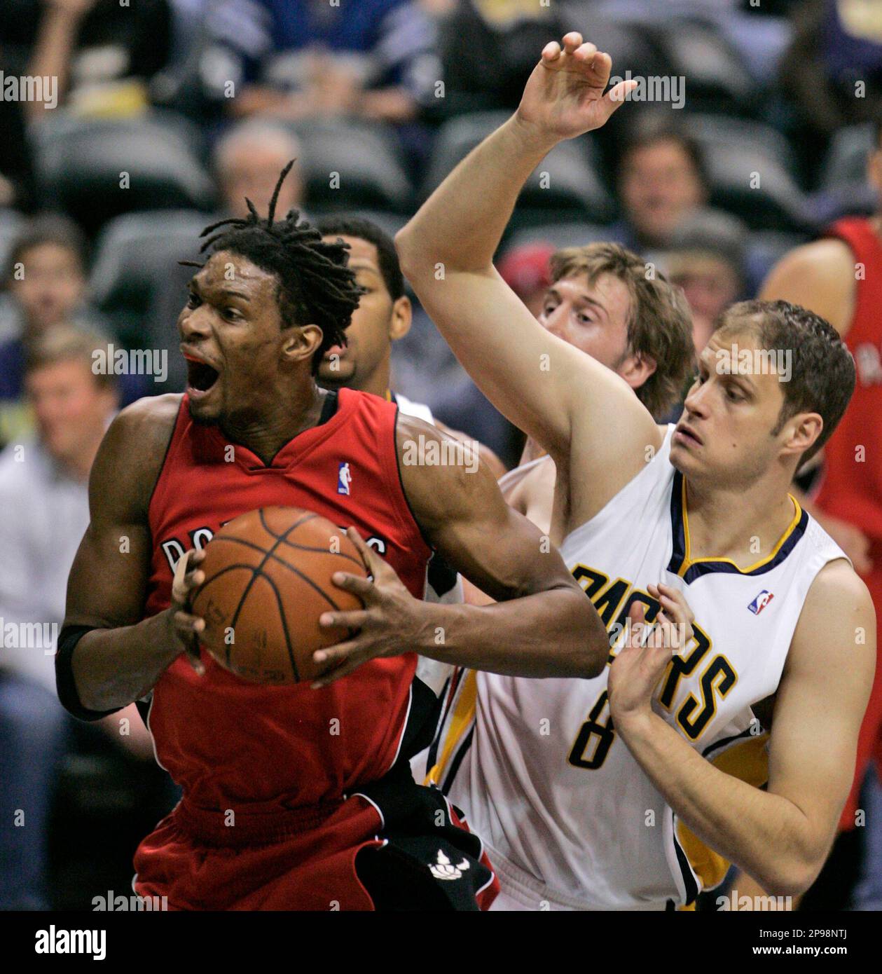 Toronto Raptors forward Chris Bosh, left, grabs a rebound against ...