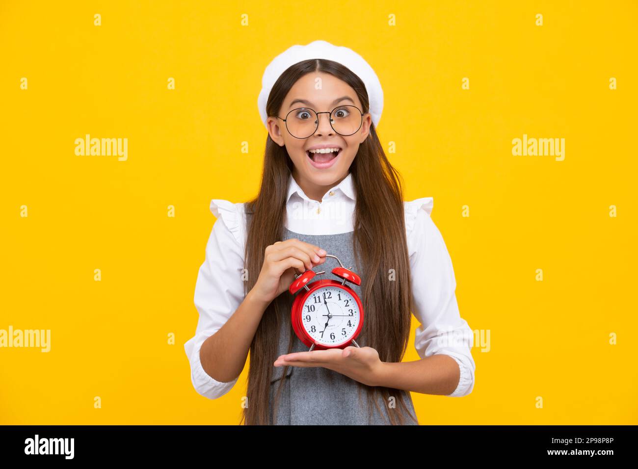 Happy girl face, positive and smiling teen girl holding clock over ...