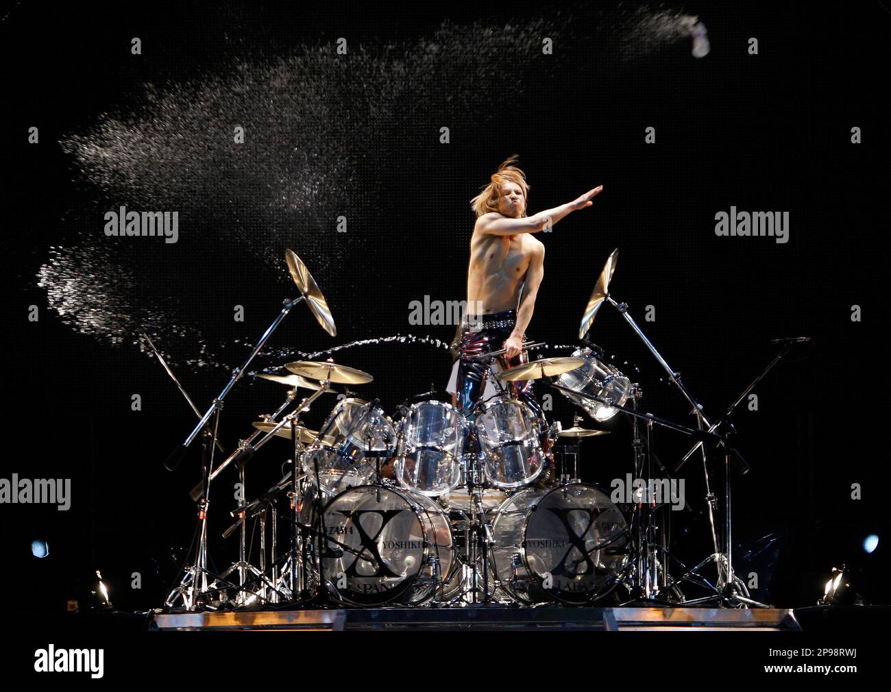 Japan's music band X Japan member Yoshiki Hayashi throws a bottle of ...