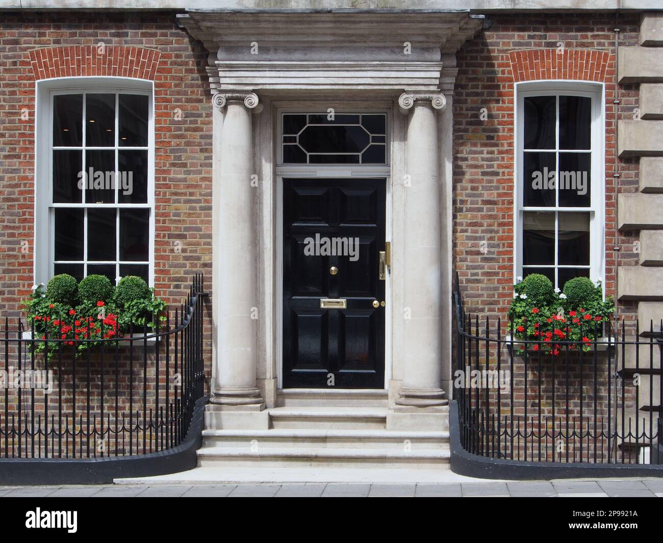 Entrance to old brick townhouse with floral planters in window Stock ...