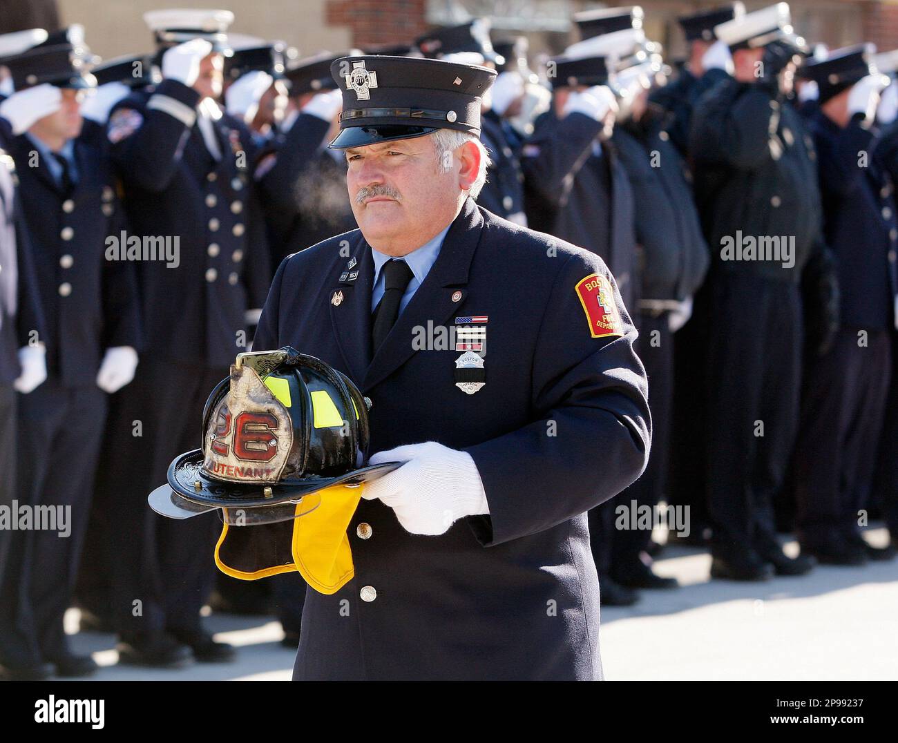 Steve Mortlock a member of Ladder 26 carries the helmet of Boston Fire ...