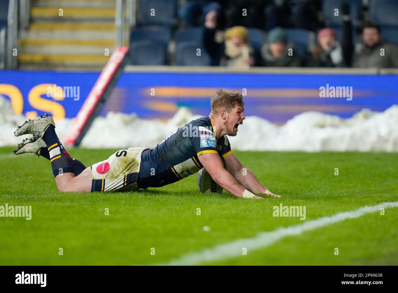 Tom Holroyd #18 of Leeds Rhinos dives over to score a try during the ...