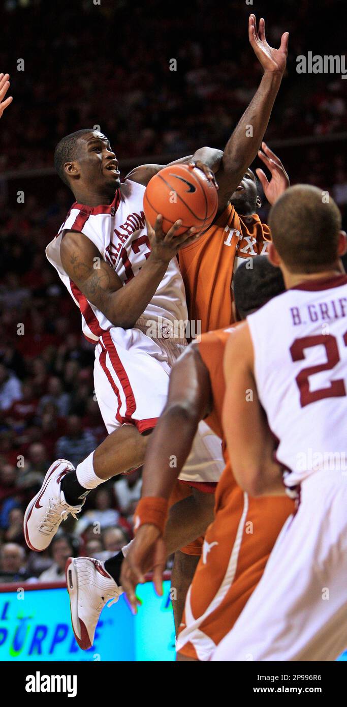 Oklahoma guard Willie Warren, left, goes up for a shot while defended ...