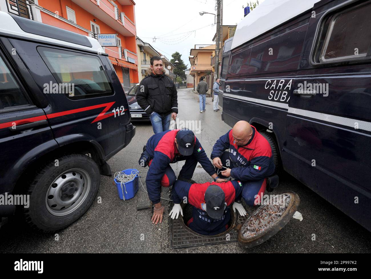 Italian Carabinieri paramilitary police officers inspect a manhole ...