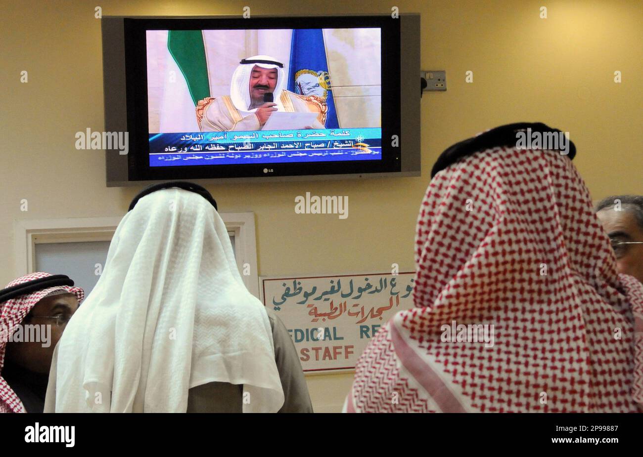 Kuwaiti men watch the Amir of Kuwait, Sheikh Sabah Al Sabah as he ...