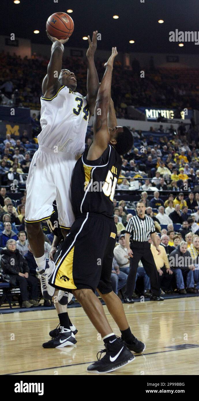 Michigan forward DeShawn Sims (34) shoots over Iowa forward Jarryd Cole ...
