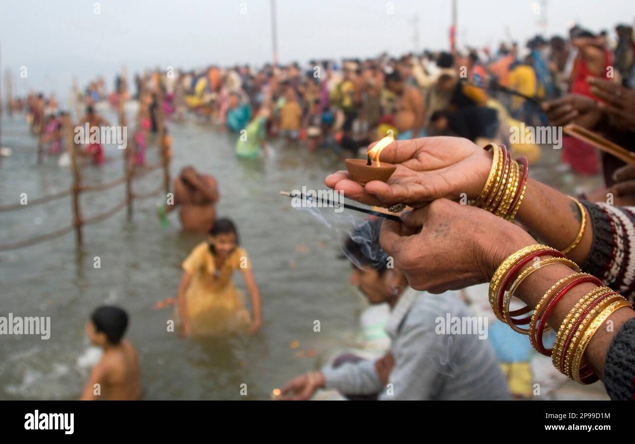 The hands of a woman is seen offering prayers with a lamp, as Hindu ...