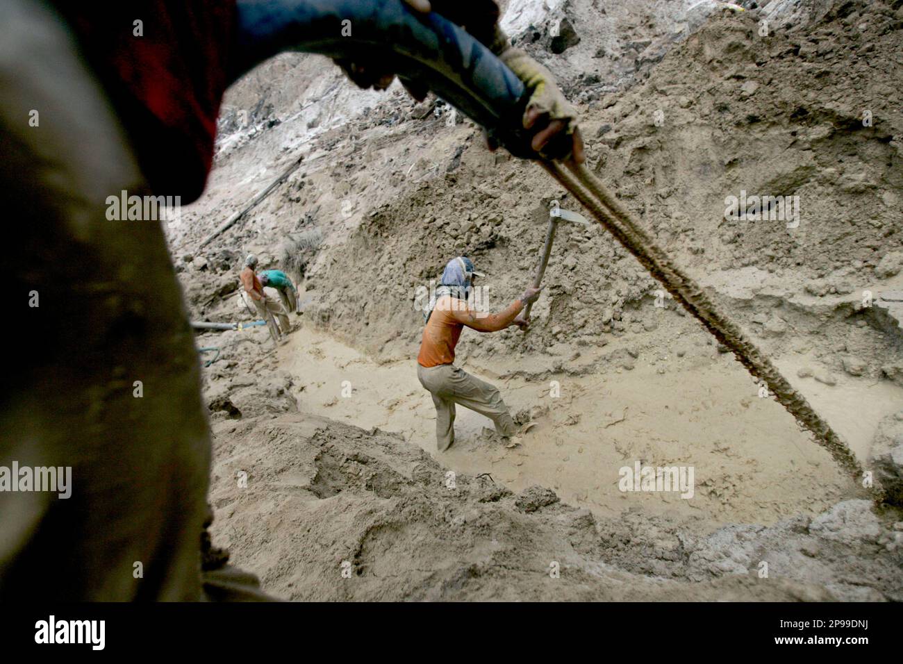Traditional gold miners use a high-pressure water jet to blast through ...