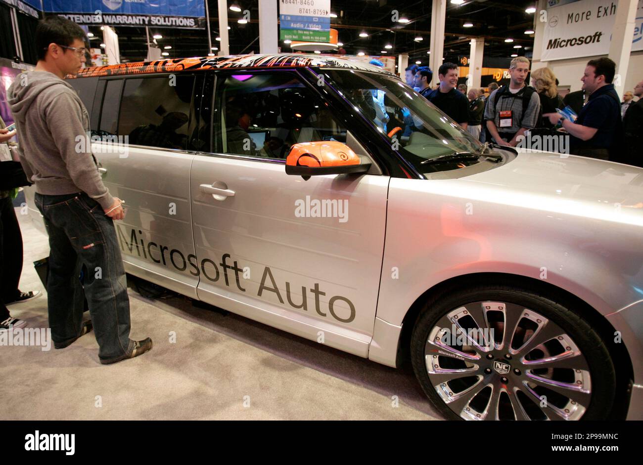 Attendees look at a vehicle loaded with several Microsoft products at ...