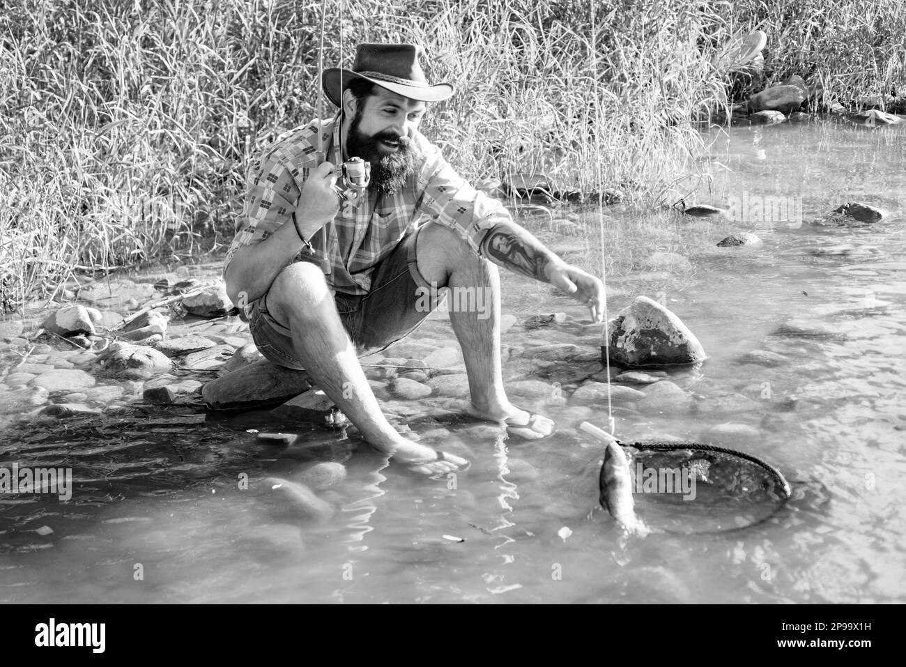 Man relaxing and fishing by lakeside. Hobby. Fisherman with rod and ...