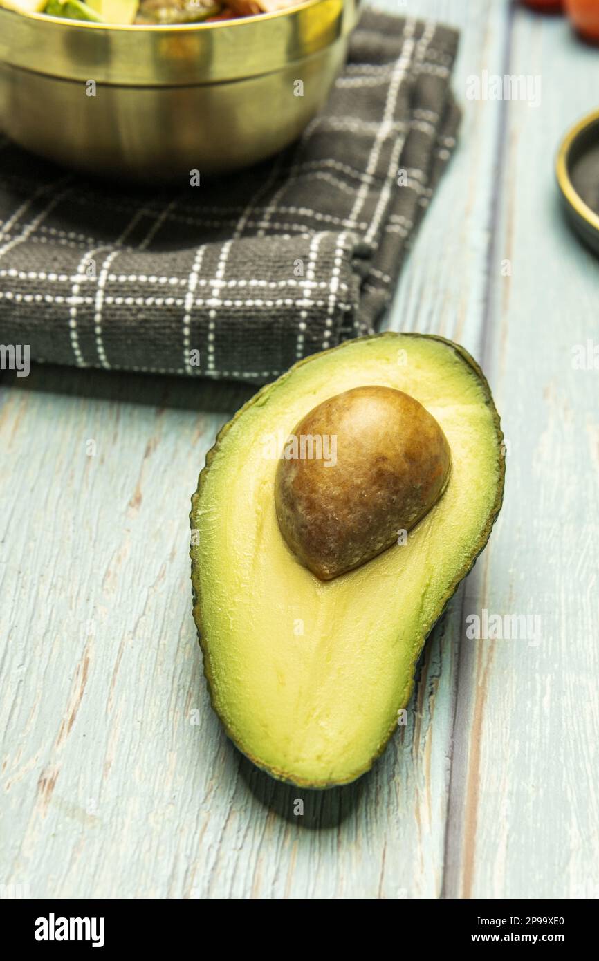 A ripe super avocado cut in half on a light blue table Stock Photo - Alamy