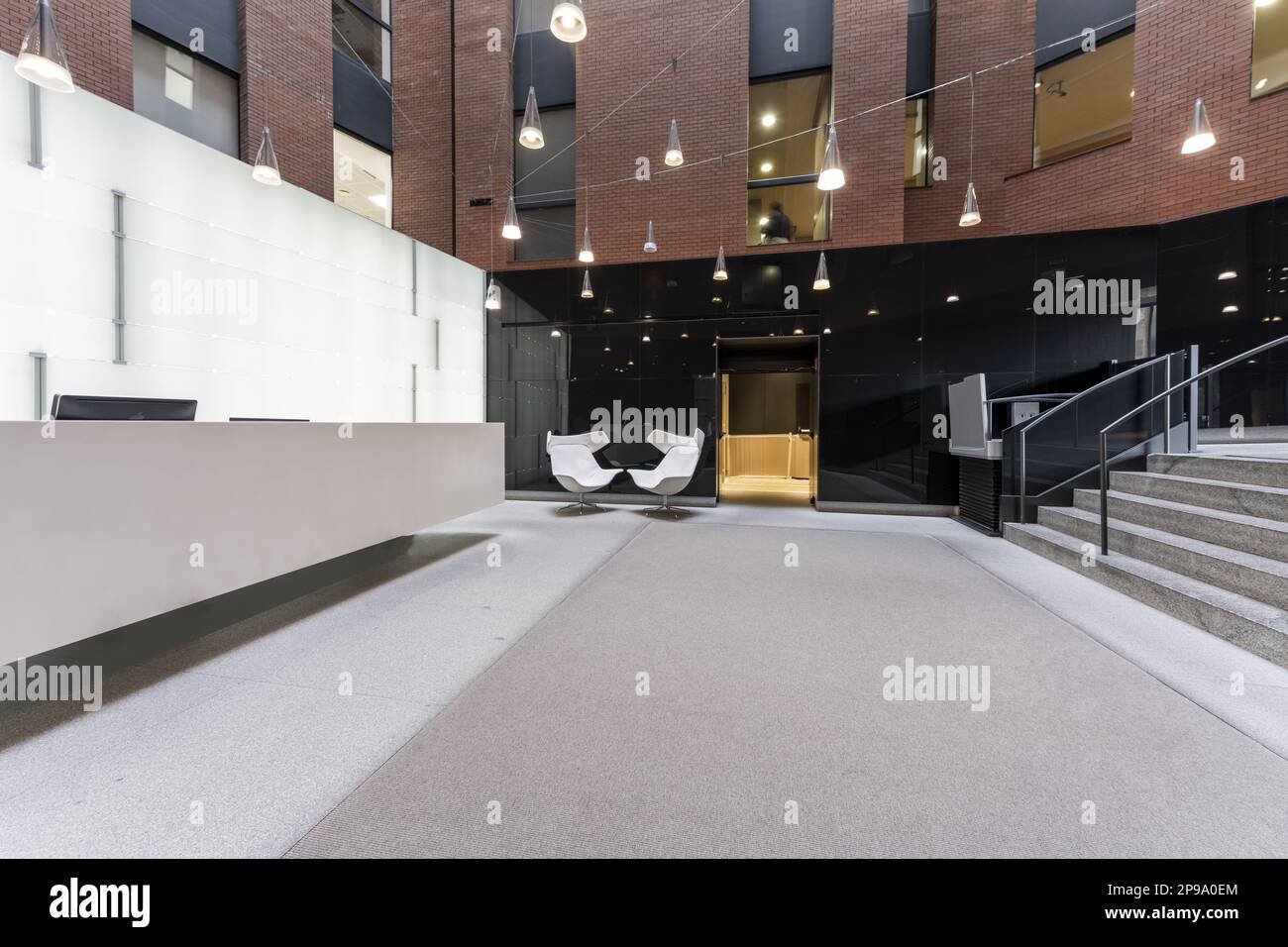 Atrium of an office building with a large reception desk, granite ...