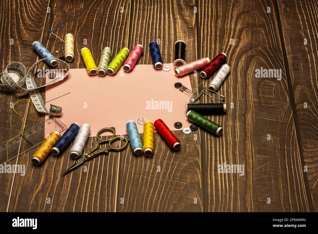 a sewing still life with a plastic ruler, needles, colored buttons ...